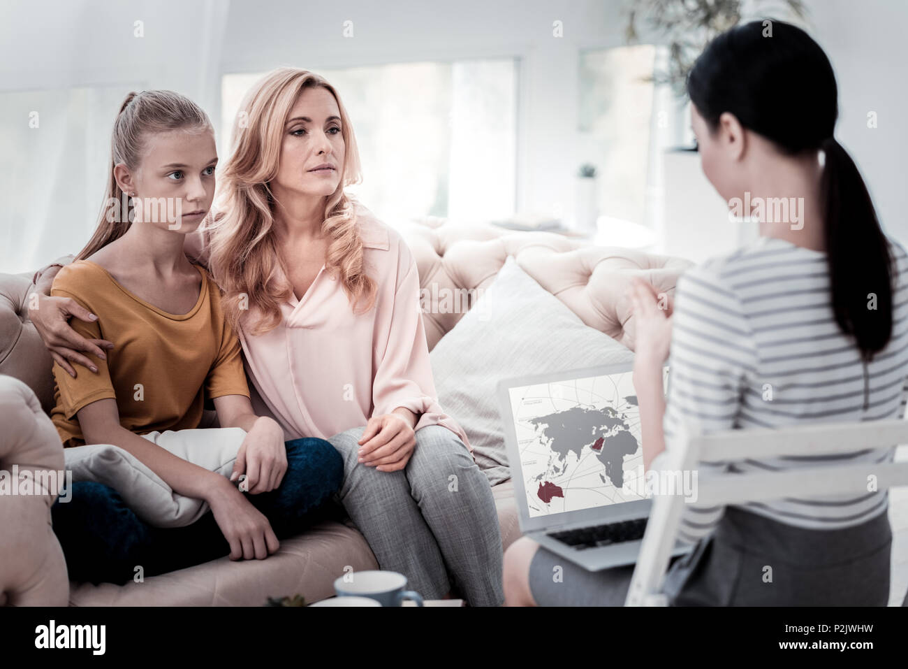 Serious mother and her daughter attending psychologist Stock Photo - Alamy