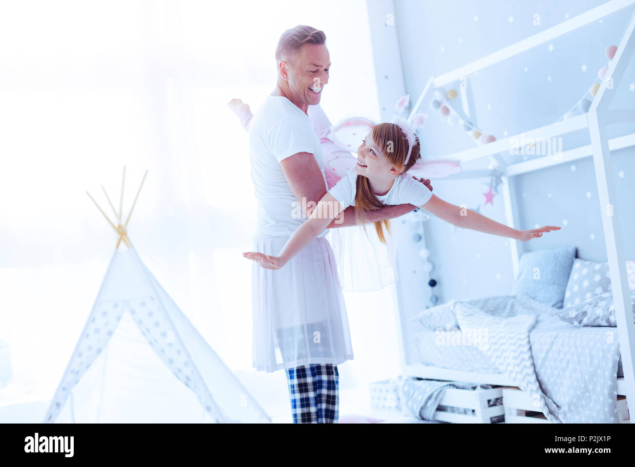 Joyful father lifting daughter while playing with her Stock Photo - Alamy