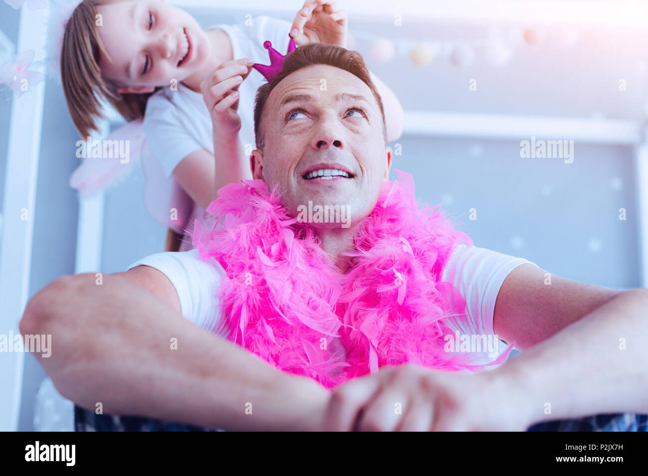 Mindful daddy looking at daughter adjusting crown on his head Stock ...