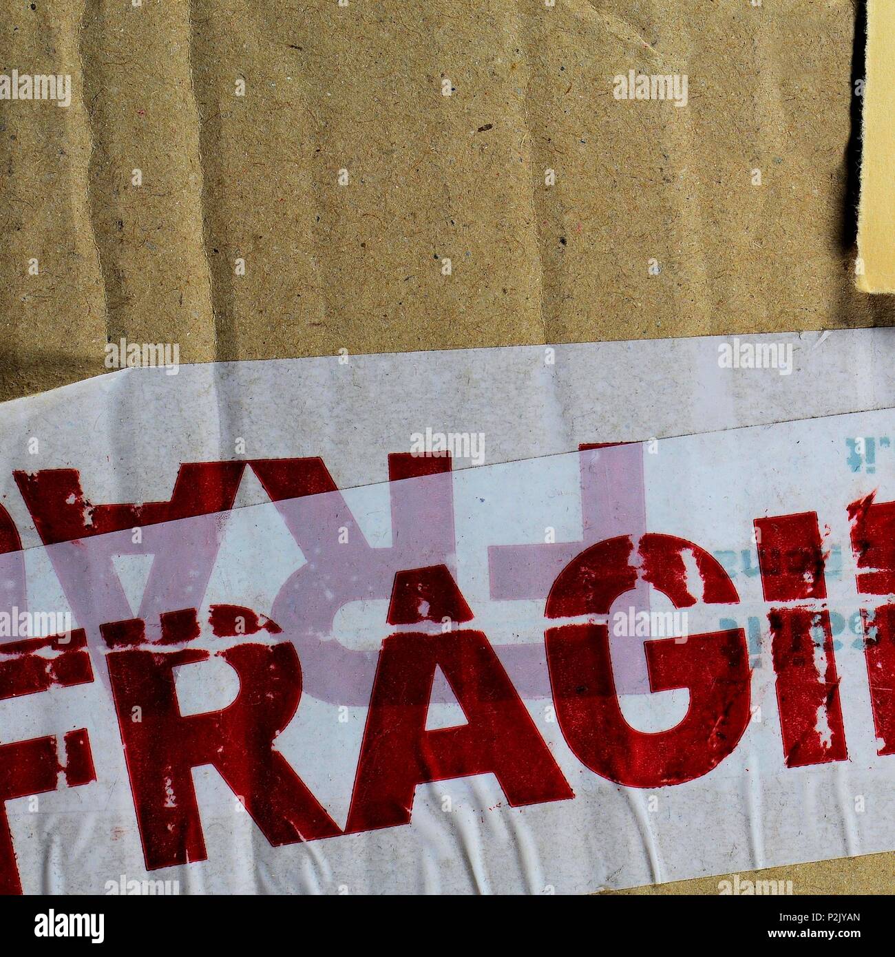 Adhesive tape with FRAGILE word on old eroded cardboard Stock Photo - Alamy