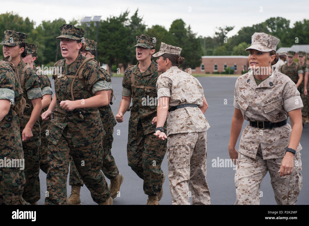 U.S. Marine Drill Instructor Staff Sgt. Karin Guajardo corrects a new ...