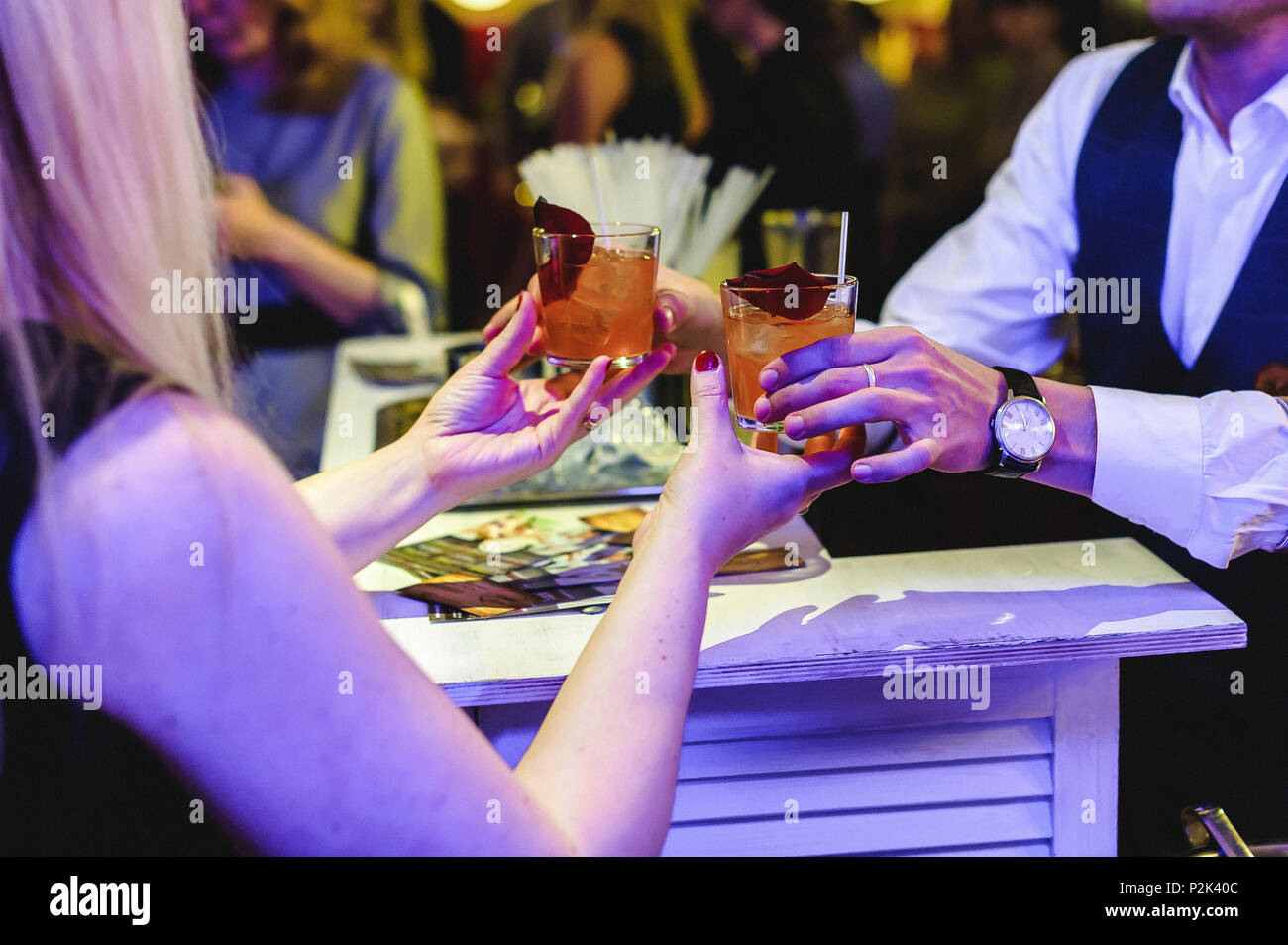 people are resting at a banquet. girl holding a glass of drink in her ...