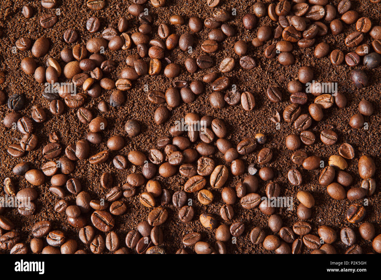 Coffee beans on coffee powder. Macro shot Stock Photo - Alamy