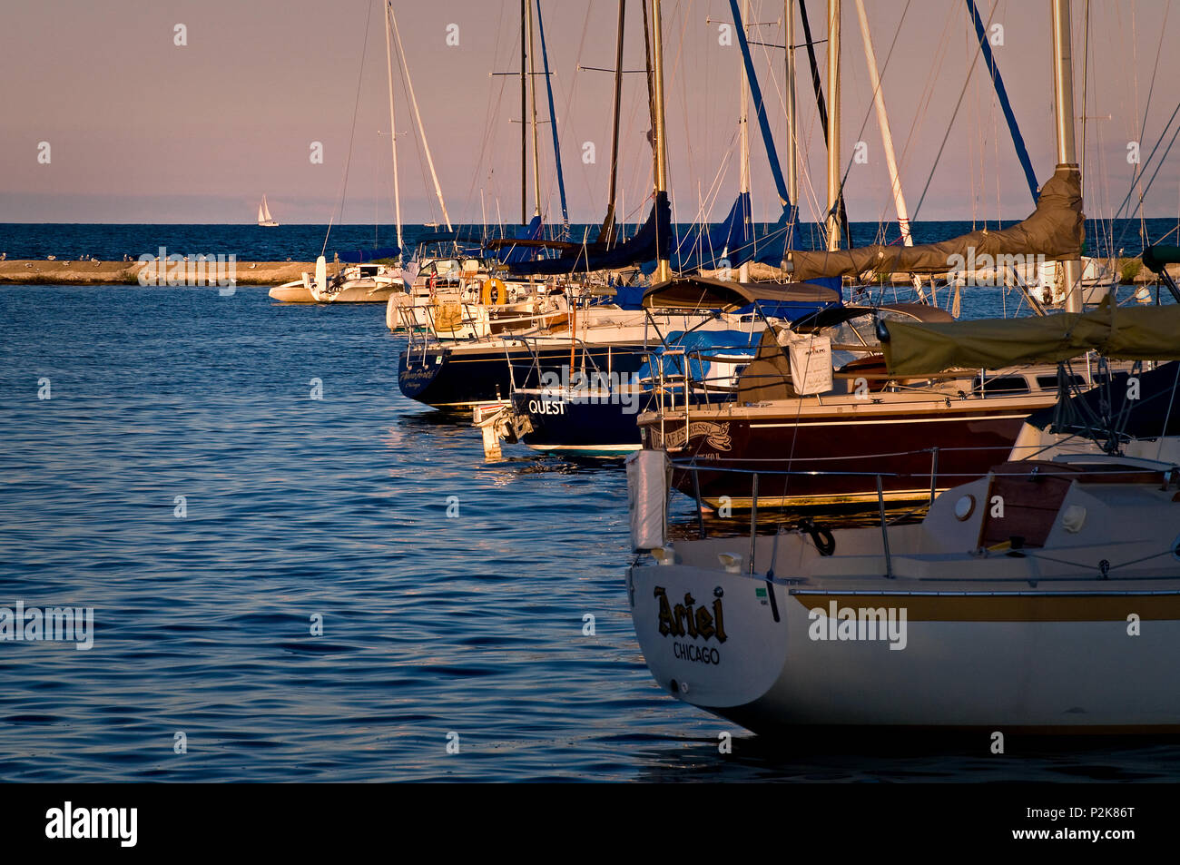 Sailboats rest peacefully at their moorings as the sun sets on Burnham ...