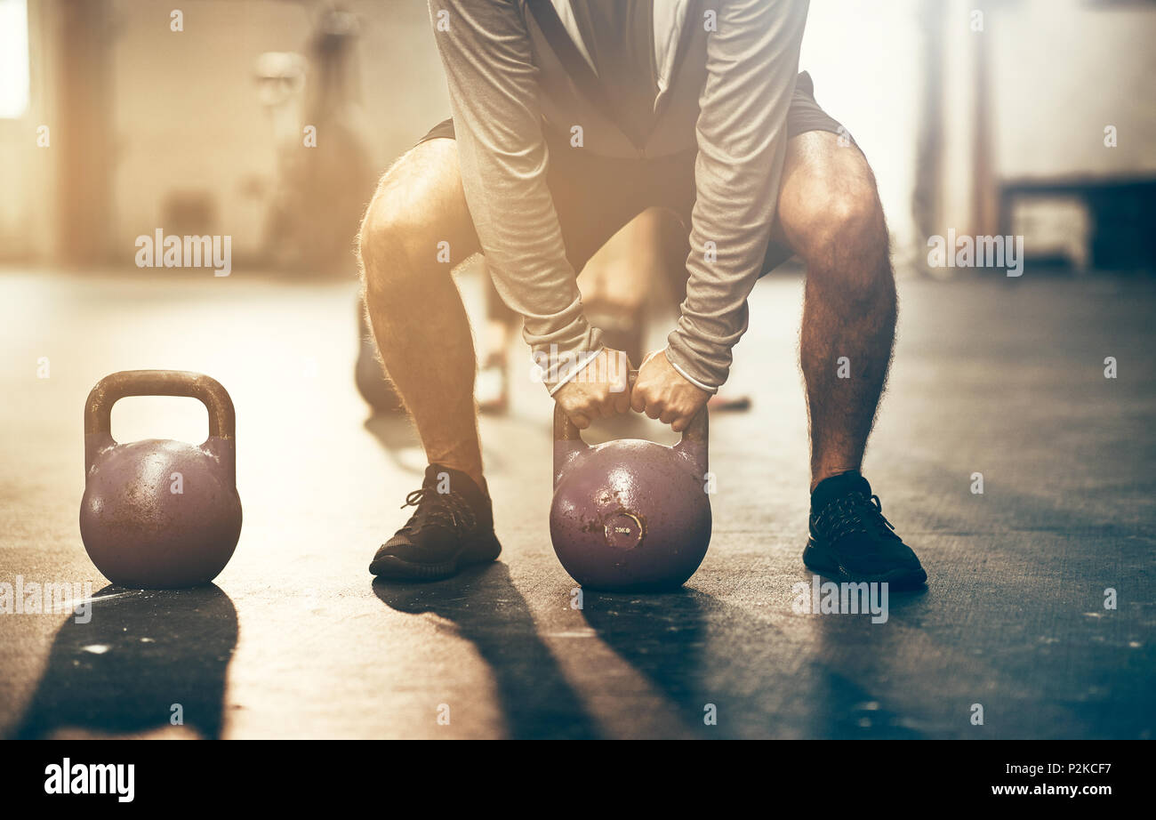 Fit man in sportswear preparing to lift a dumbbell while working out ...