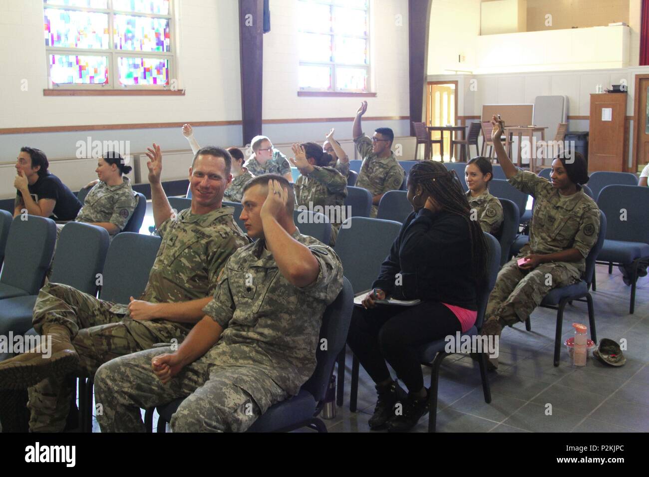 Soldiers raise their hands to ask questions to members of the panel ...