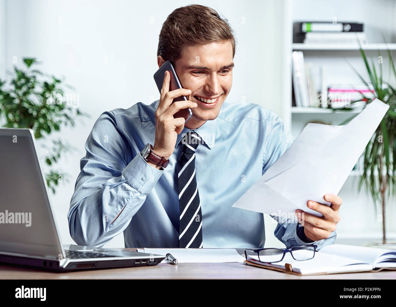 Worker talking on the phone and looks at the documents. Photo of ...