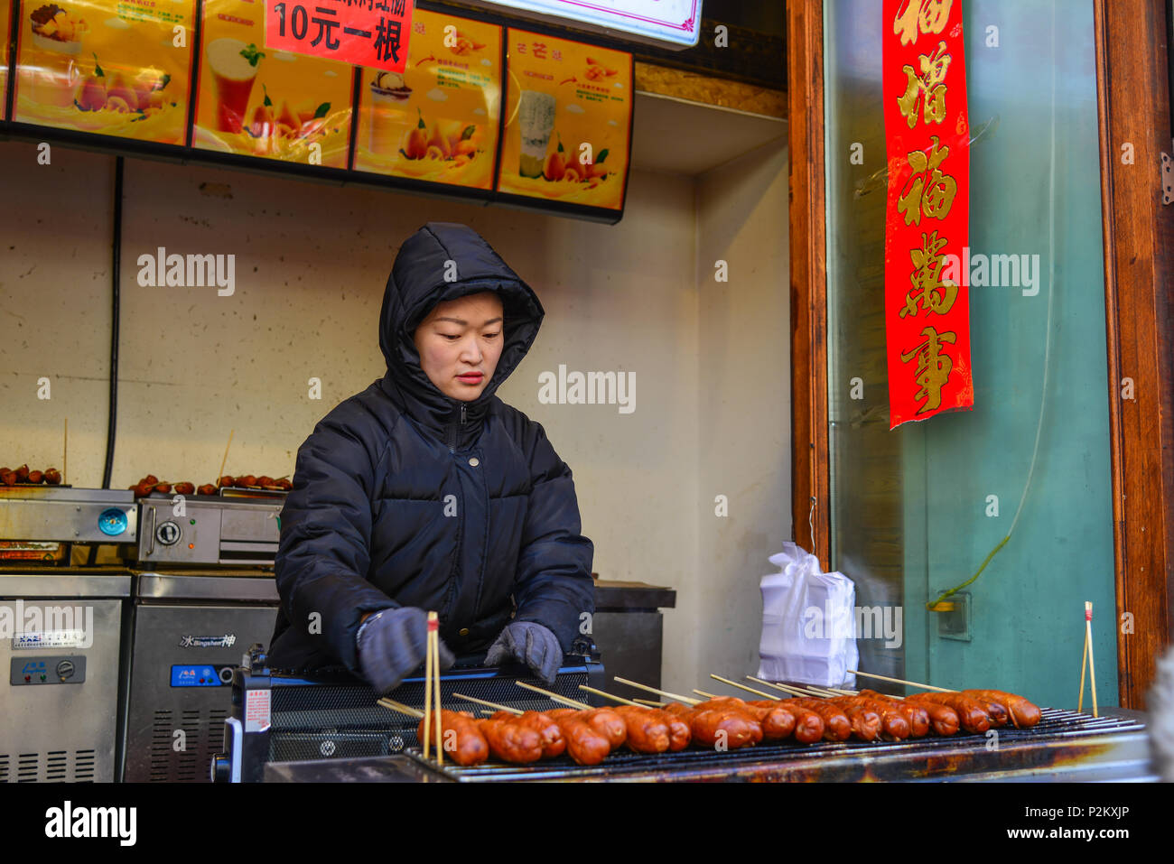 Harbin, China - Feb 22, 2018. A vendor selling food on walking street ...