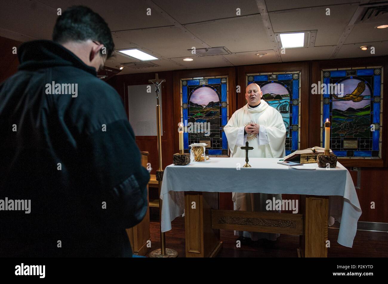 Lt. j.g. Jason Burchell, a Navy chaplain, performs roman catholic mass ...