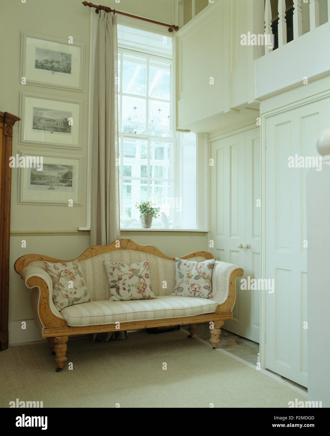 Regency style sofa below interior window in white country hall Stock ...