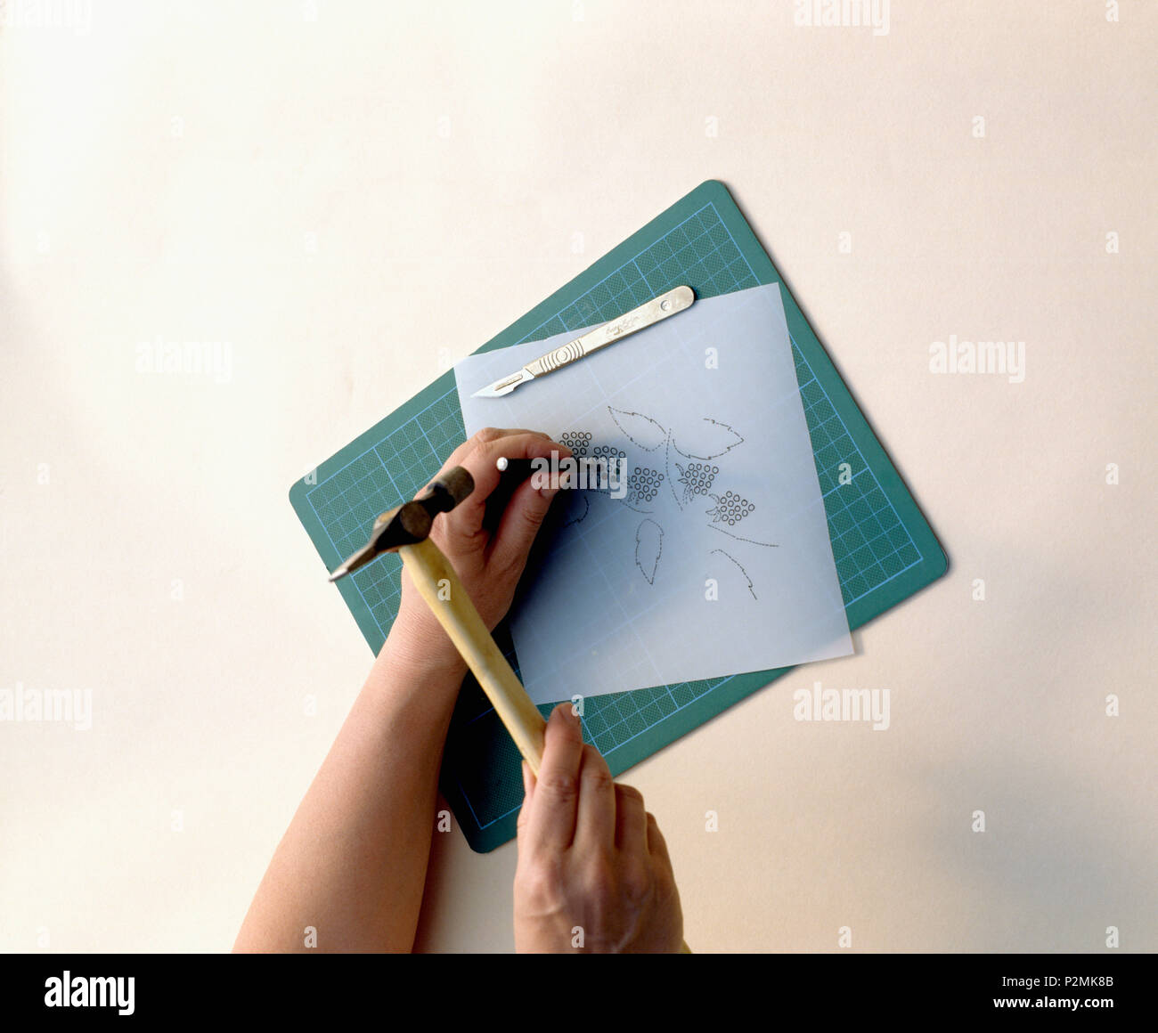 Close-up of hand using hammer and pen to mark tracing paper Hand ...