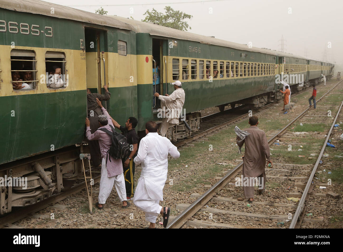 Lahore, Pakistan. 15th June, 2018. People ride on a crowded passenger ...