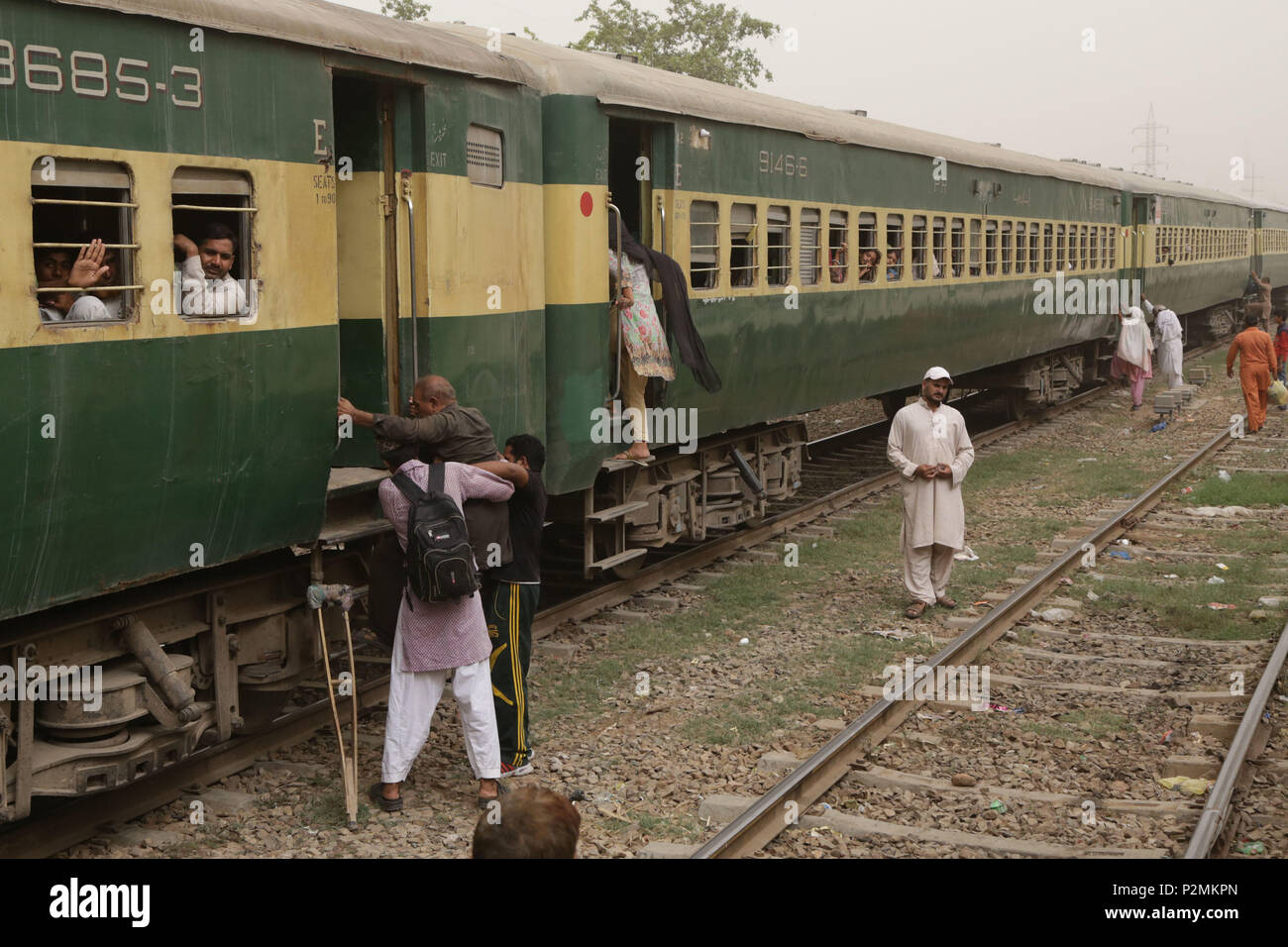 Lahore, Pakistan. 15th June, 2018. People ride on a crowded passenger ...