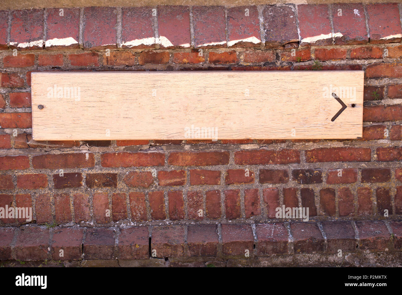 Wooden signpost with arrow on old brick wall Stock Photo - Alamy