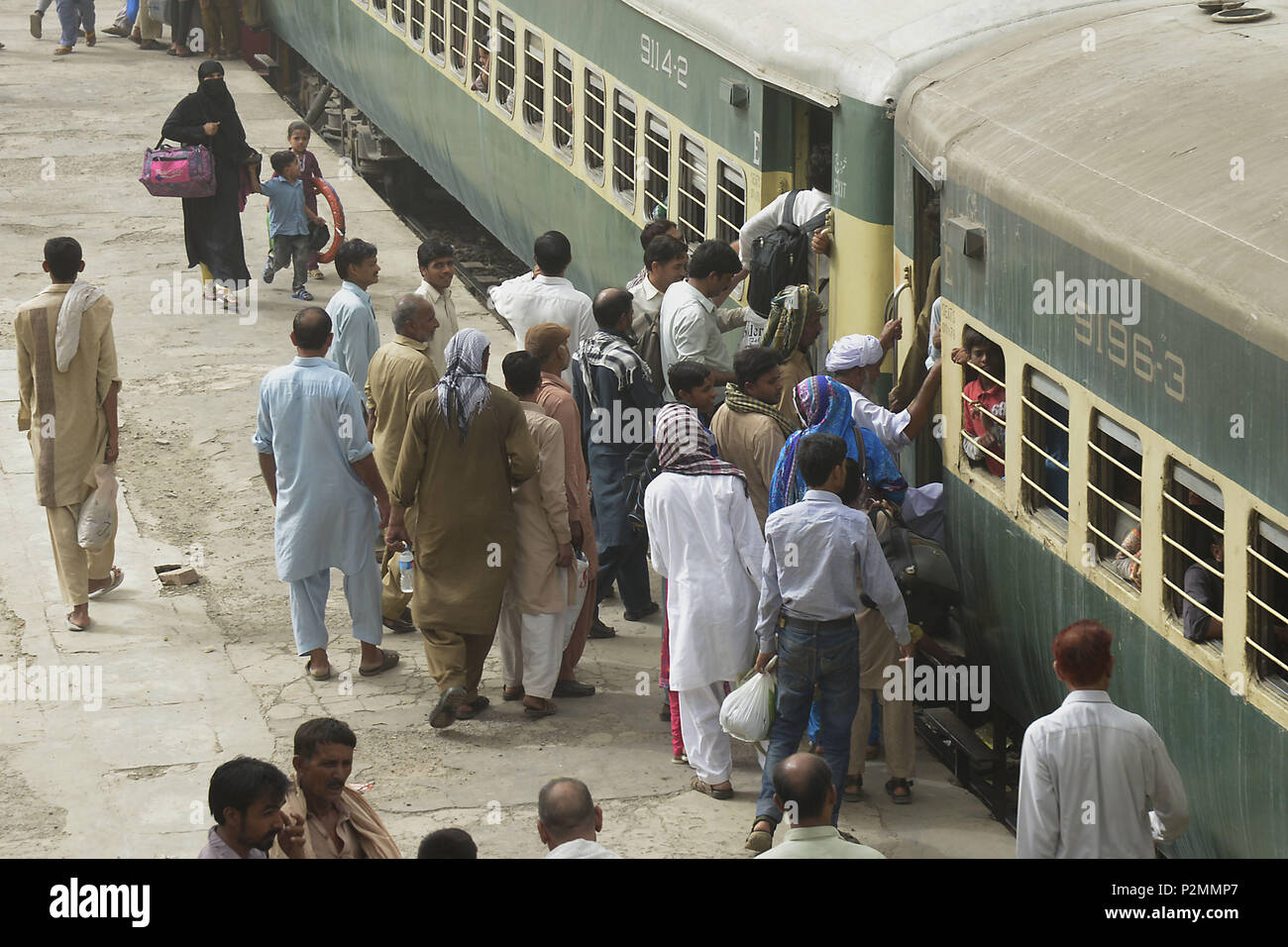 Lahore, Pakistan. 14th June, 2018. People ride on a crowded passenger ...