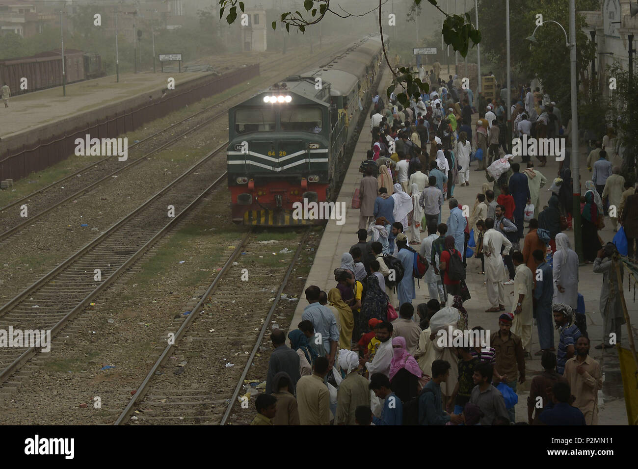 Lahore, Pakistan. 14th June, 2018. People ride on a crowded passenger ...