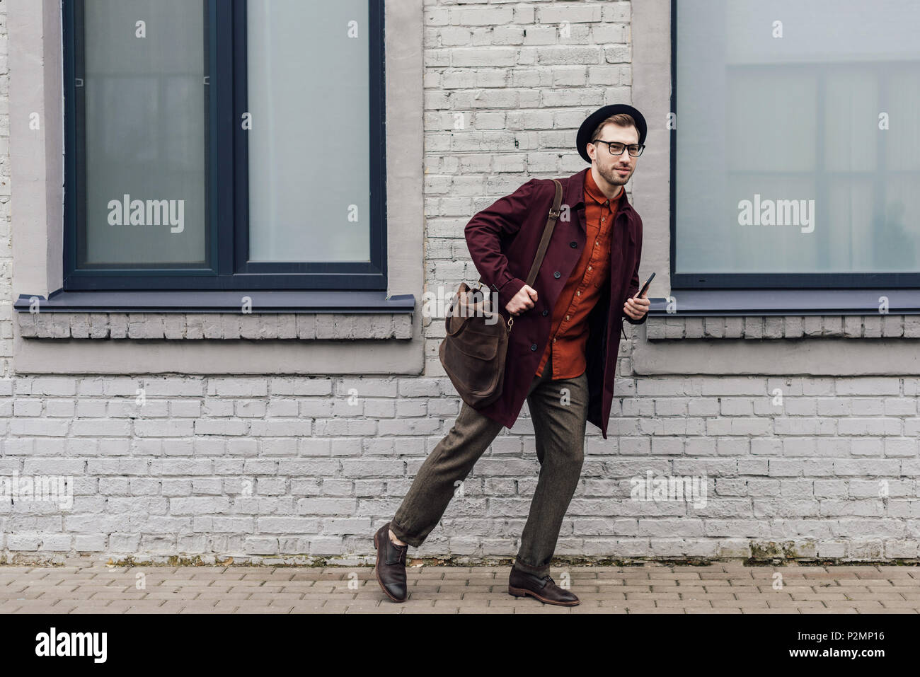 stylish man with bag and smartphone running on street Stock Photo - Alamy