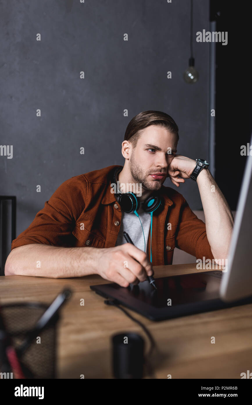 Exhausted young creative designer working hi-res stock photography and ...