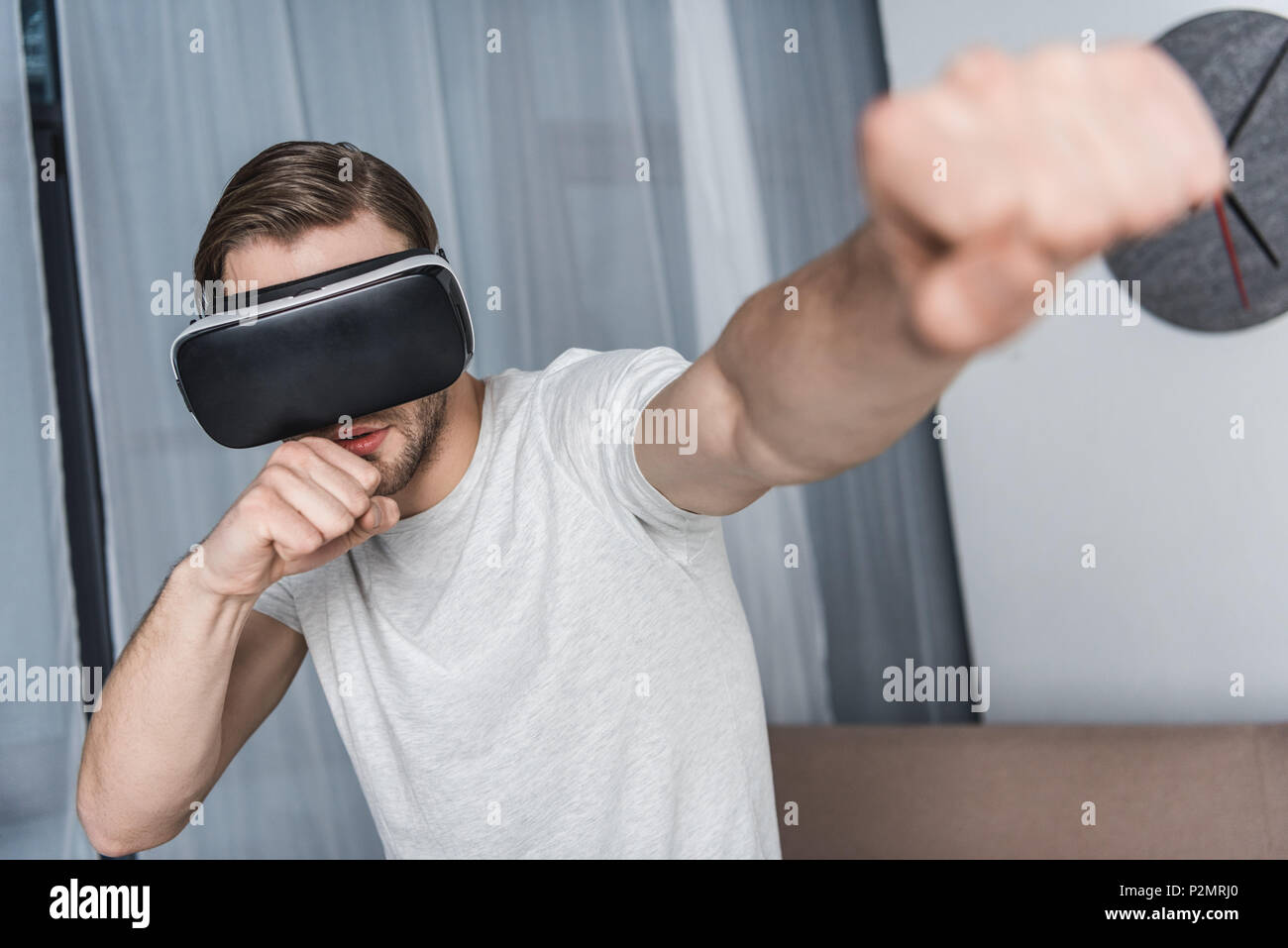 handsome young man in virtual reality headset playing fighting game ...