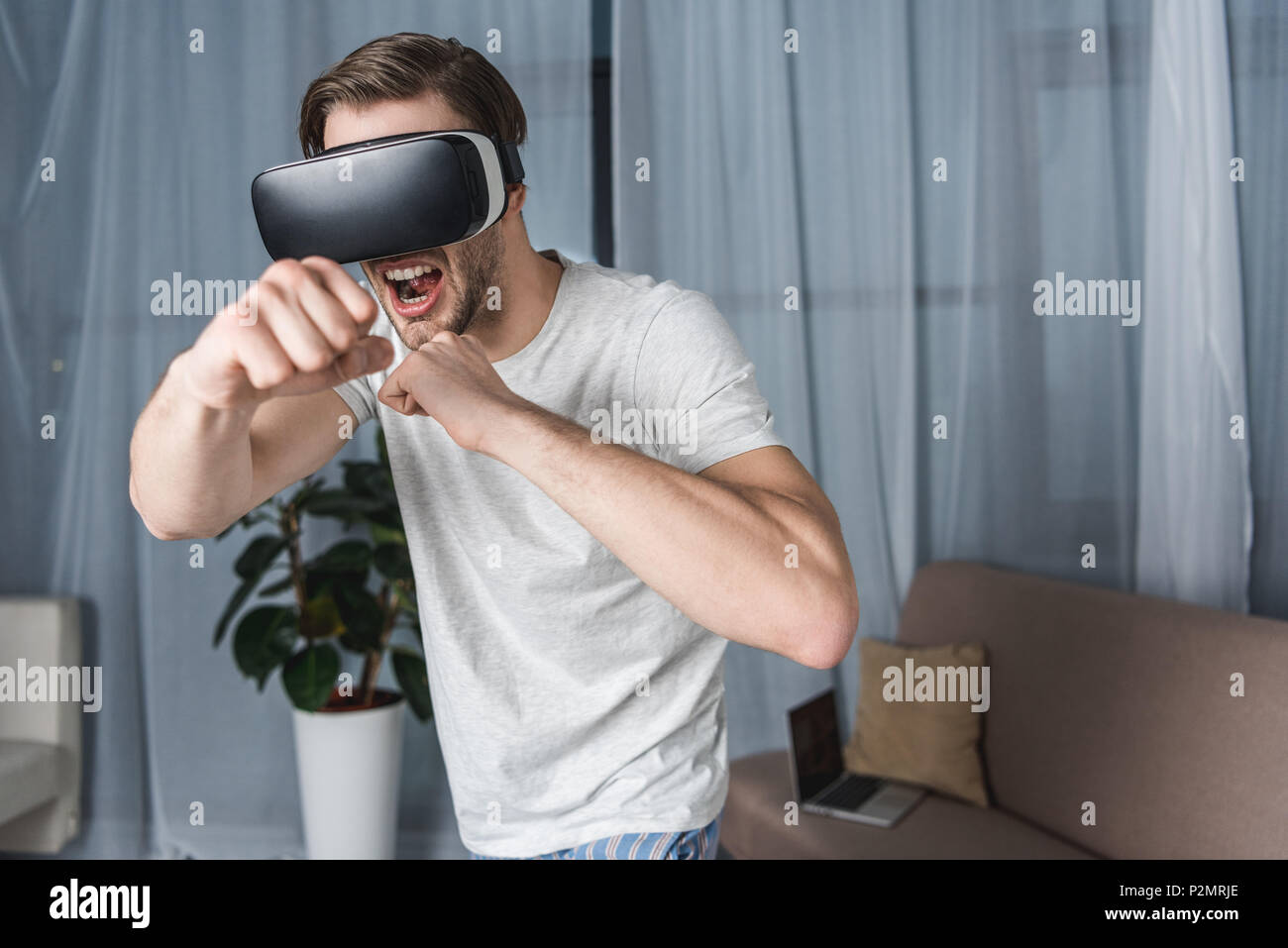 angry young man in virtual reality headset playing fighting game Stock ...