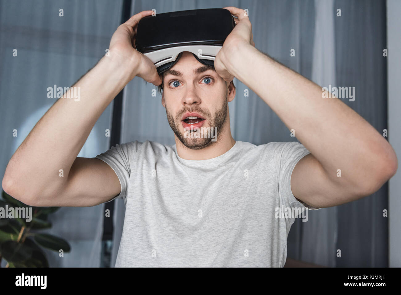 shocked young man in virtual reality headset Stock Photo - Alamy