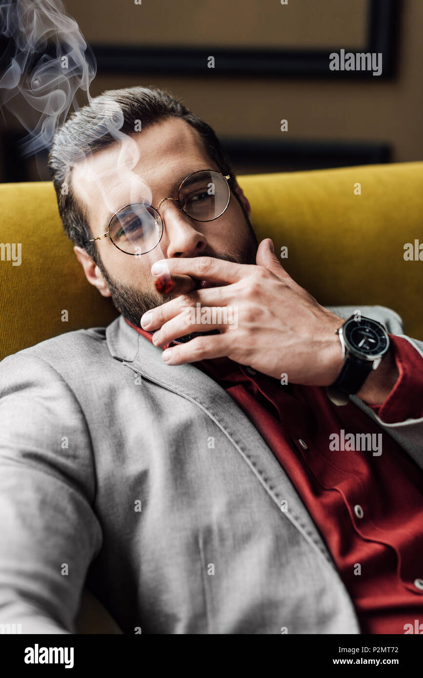 Young man smoking on sofa hi-res stock photography and images - Alamy