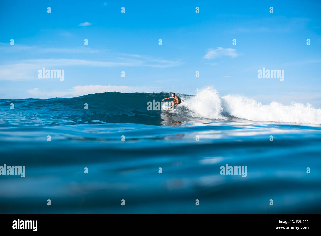 young sporty man riding on waves on sunny day in ocean Stock Photo - Alamy