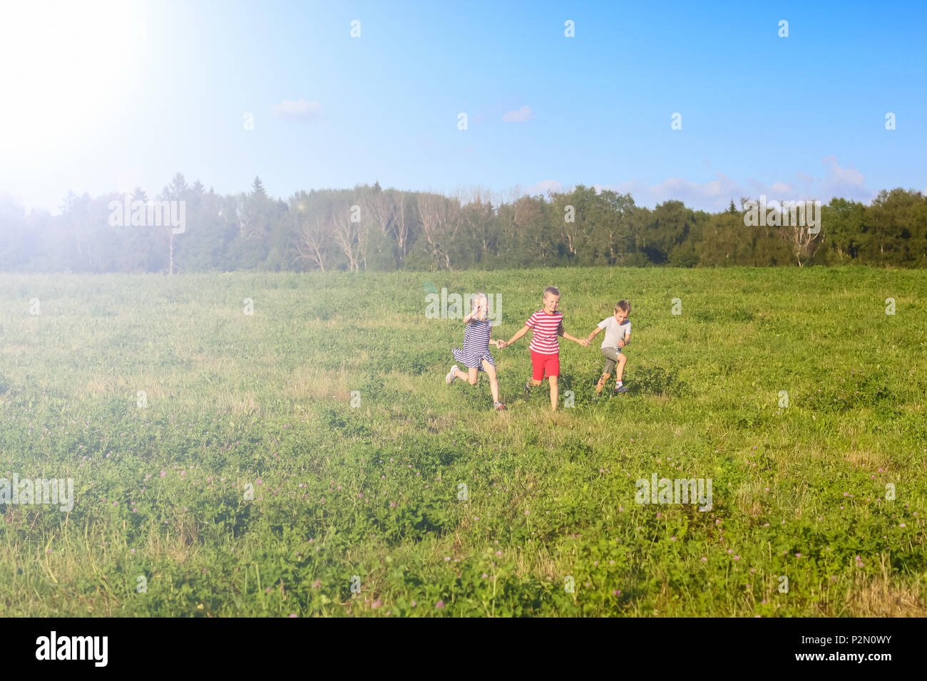 Happy children running in spring field in the daytime Stock Photo - Alamy