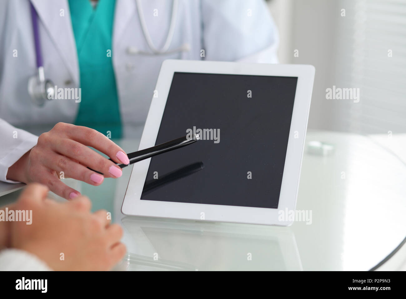 Doctor and patient, close-up. Physician pointing into laptop computer ...