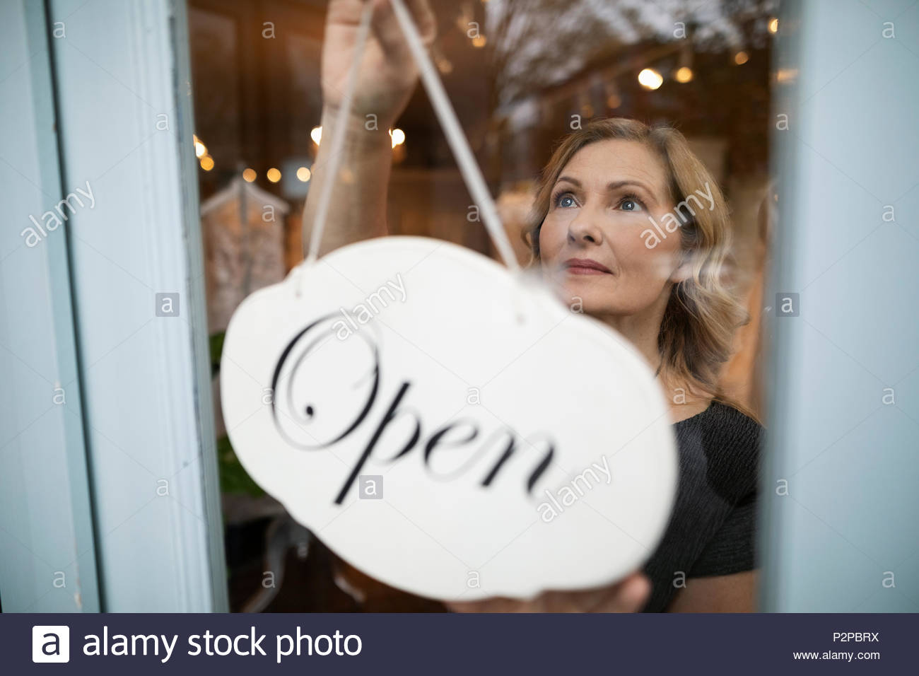 Women hanging open sign hi-res stock photography and images - Alamy
