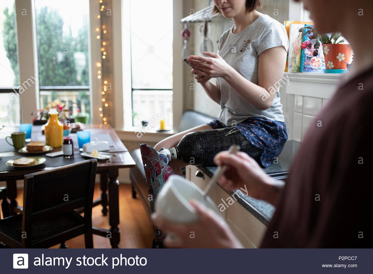 Young woman amputee watching boyfriend cooking in kitchen Stock Photo ...