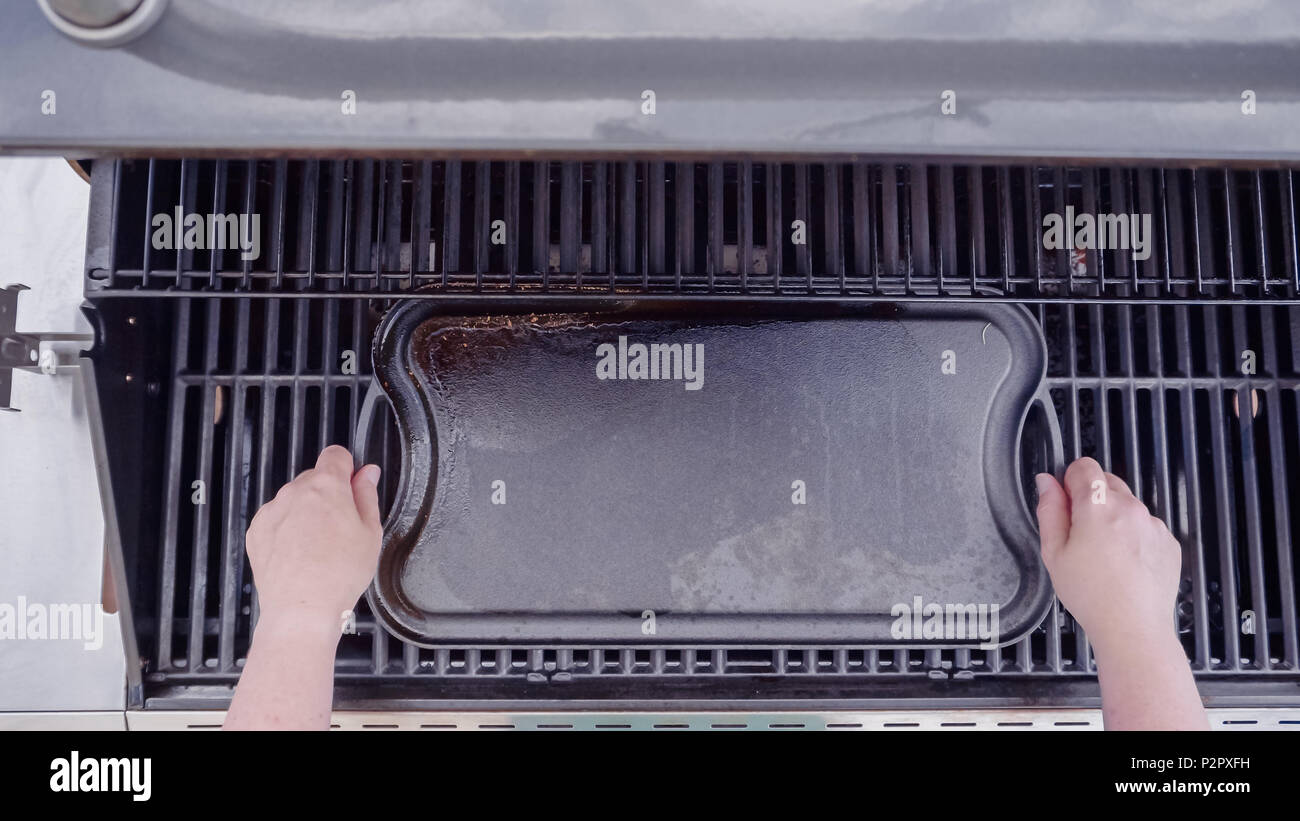 Empty cast iron griddle on outdoor gas grill Stock Photo - Alamy