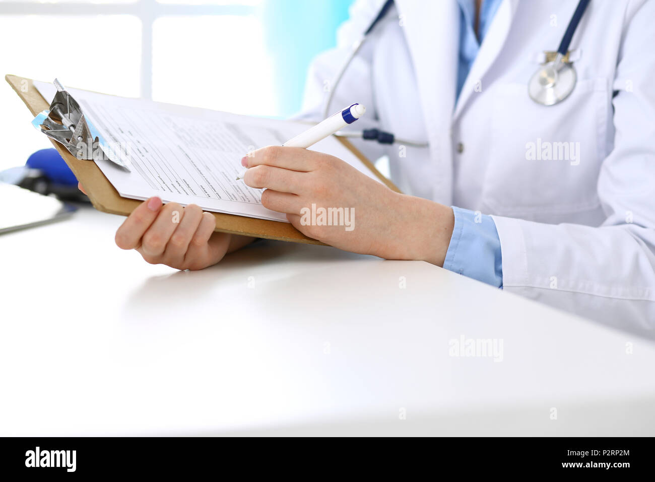 Female doctor filling up medical form on clipboard closeup. Healthcare ...