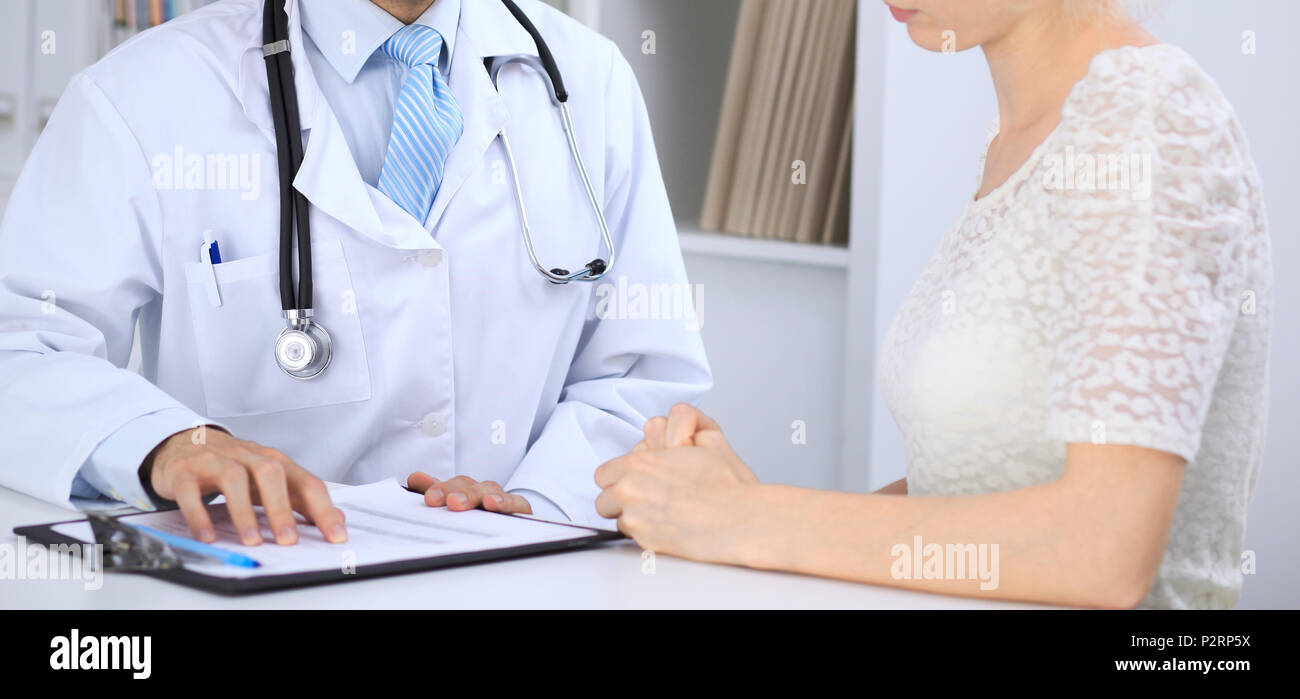 Doctor and patient talking while sitting at the table . Concept of ...