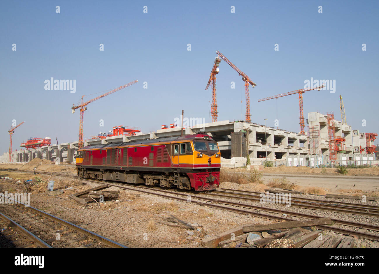 Old locomotive on railways track with construction site in background ...
