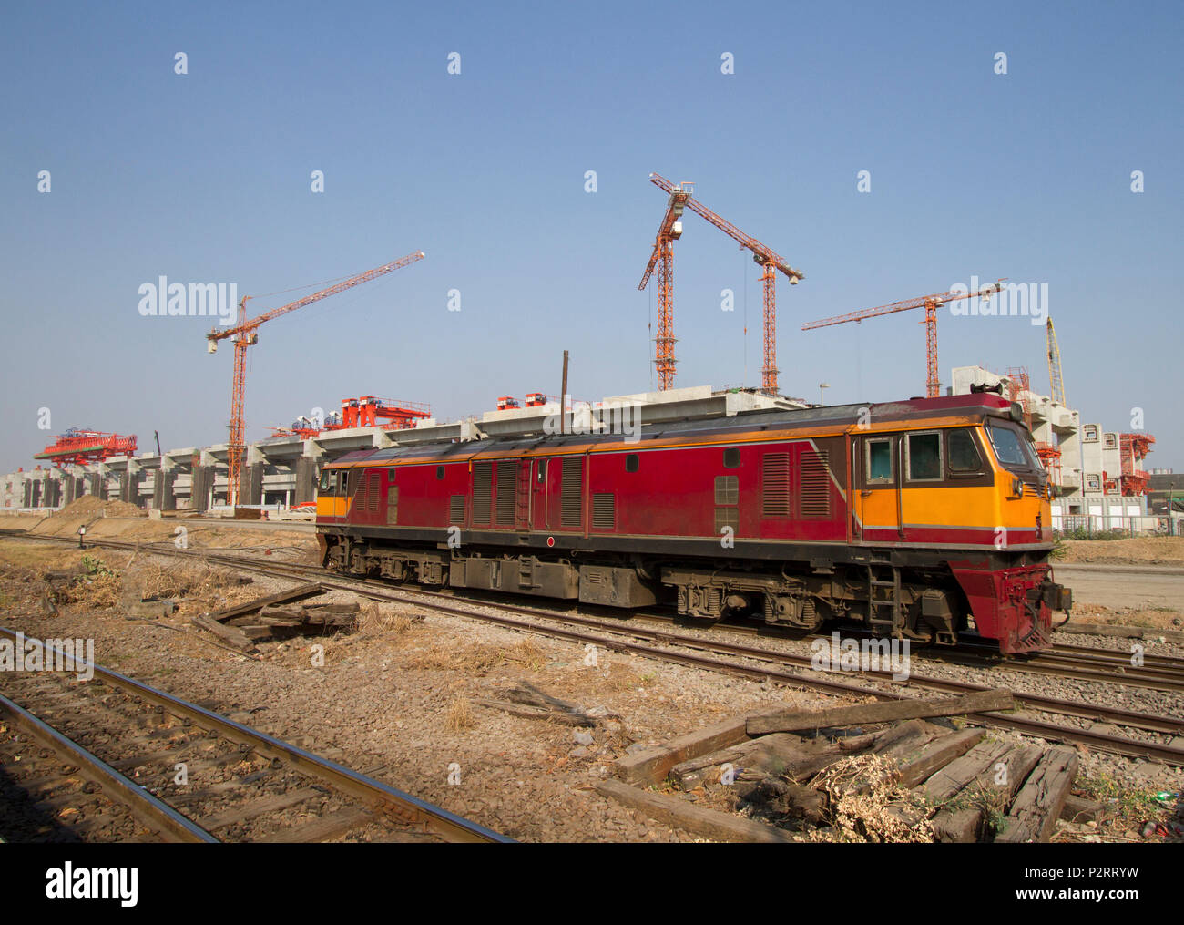 Old locomotive on railways track with construction site in background ...