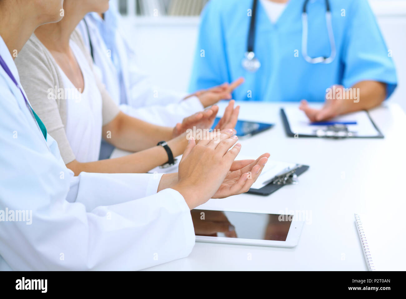 Group of doctors applauding at medical meeting. Close up of physician ...