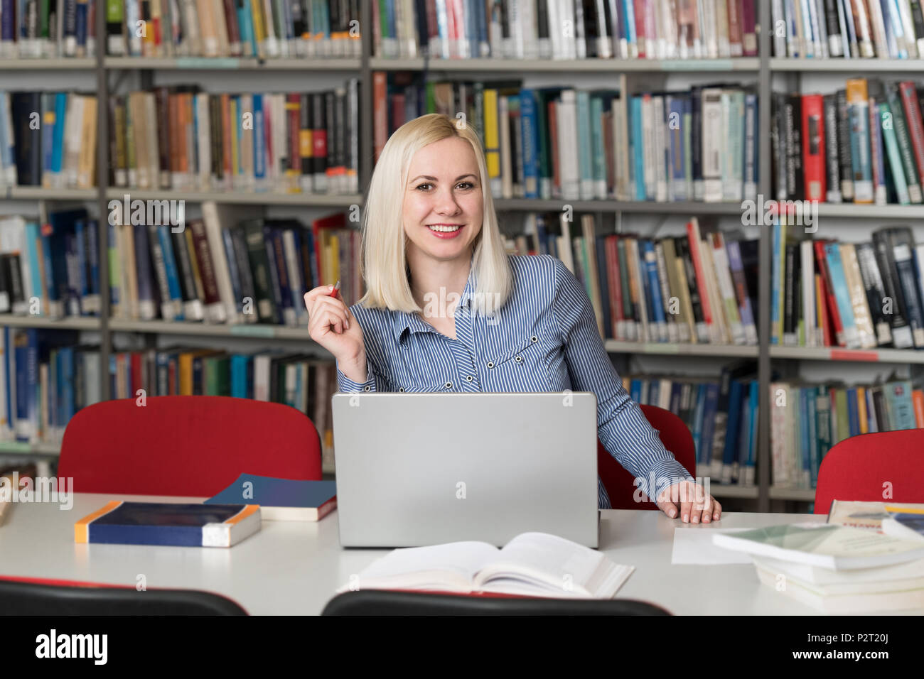 In the Library - Pretty Female Student With Books Working in a High ...