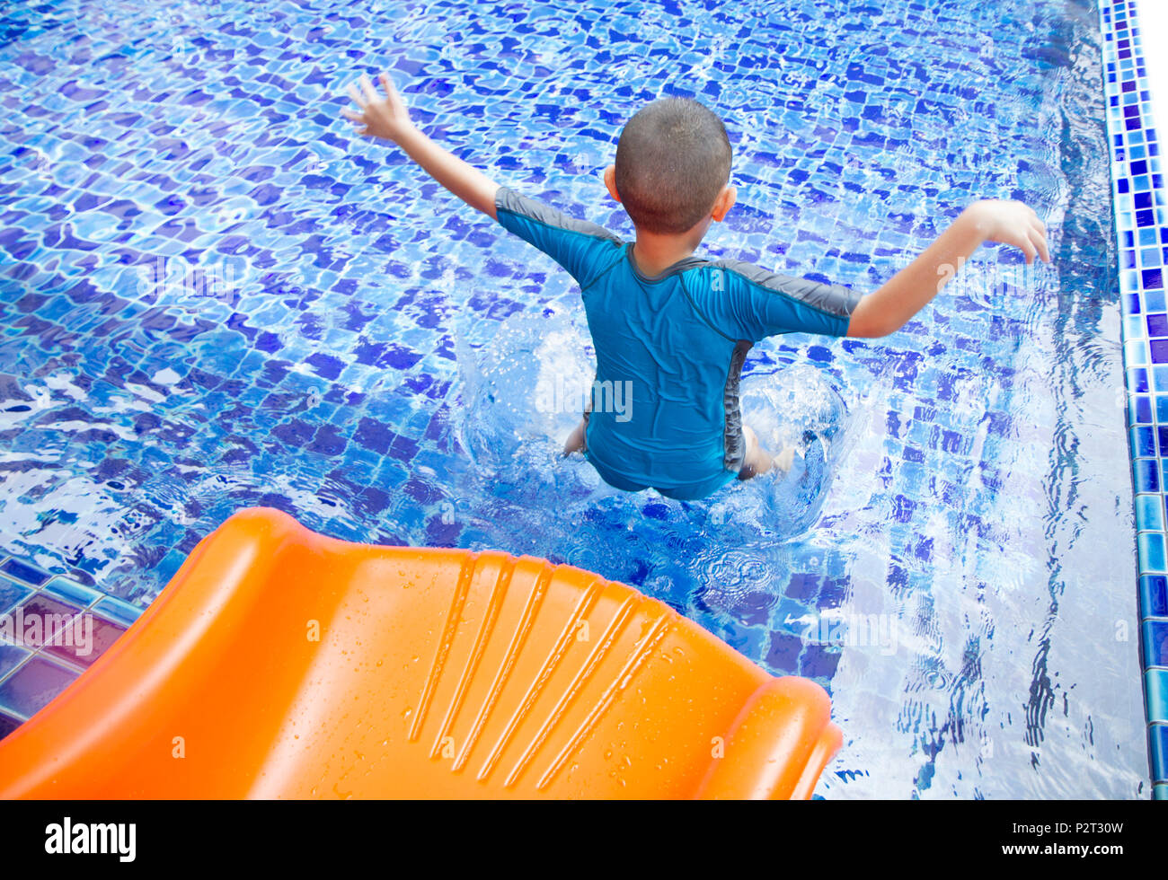 Asian boy play pool slider into blue pool Stock Photo - Alamy