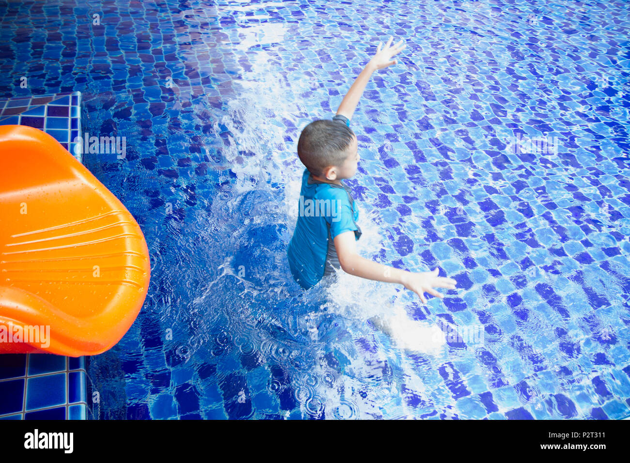 Asian boy play pool slider into blue pool Stock Photo - Alamy