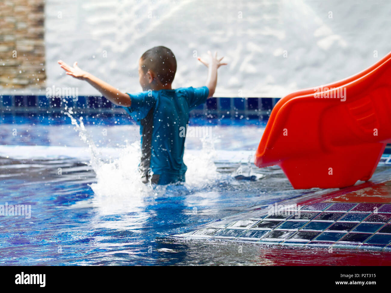 Asian boy play pool slider into blue pool Stock Photo - Alamy