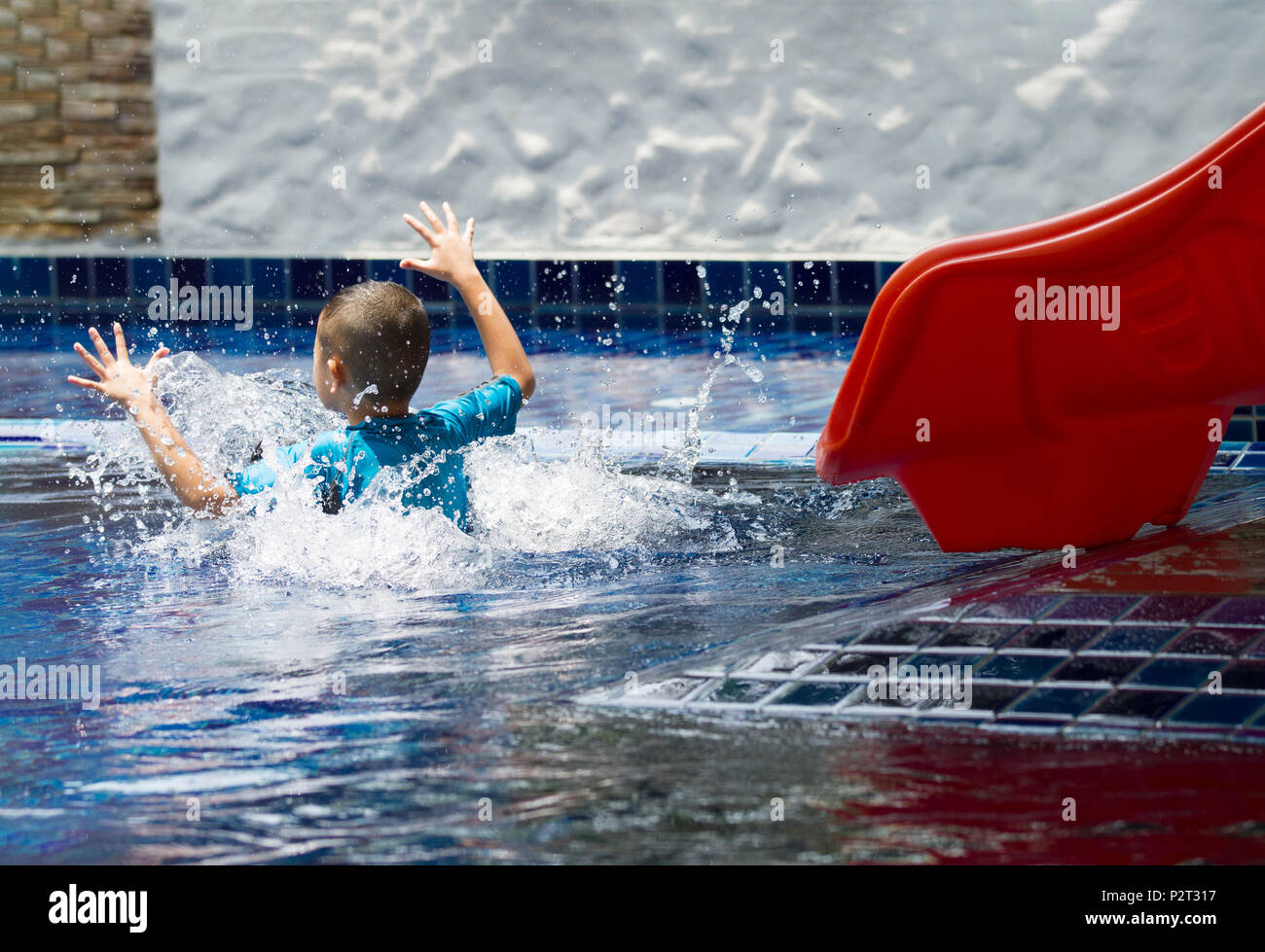 Asian boy play pool slider into blue pool Stock Photo - Alamy