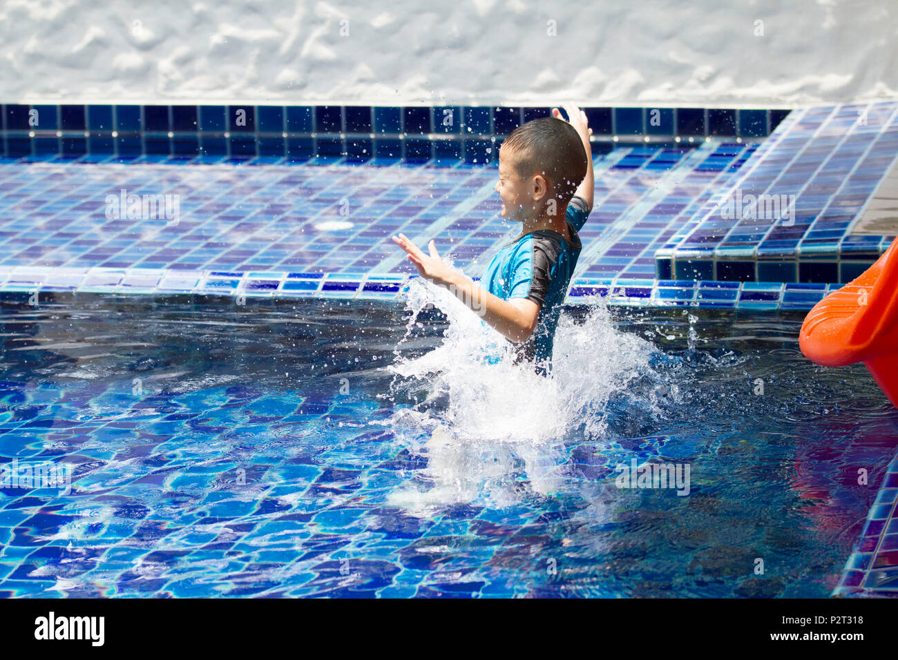 Asian boy play pool slider into blue pool Stock Photo - Alamy