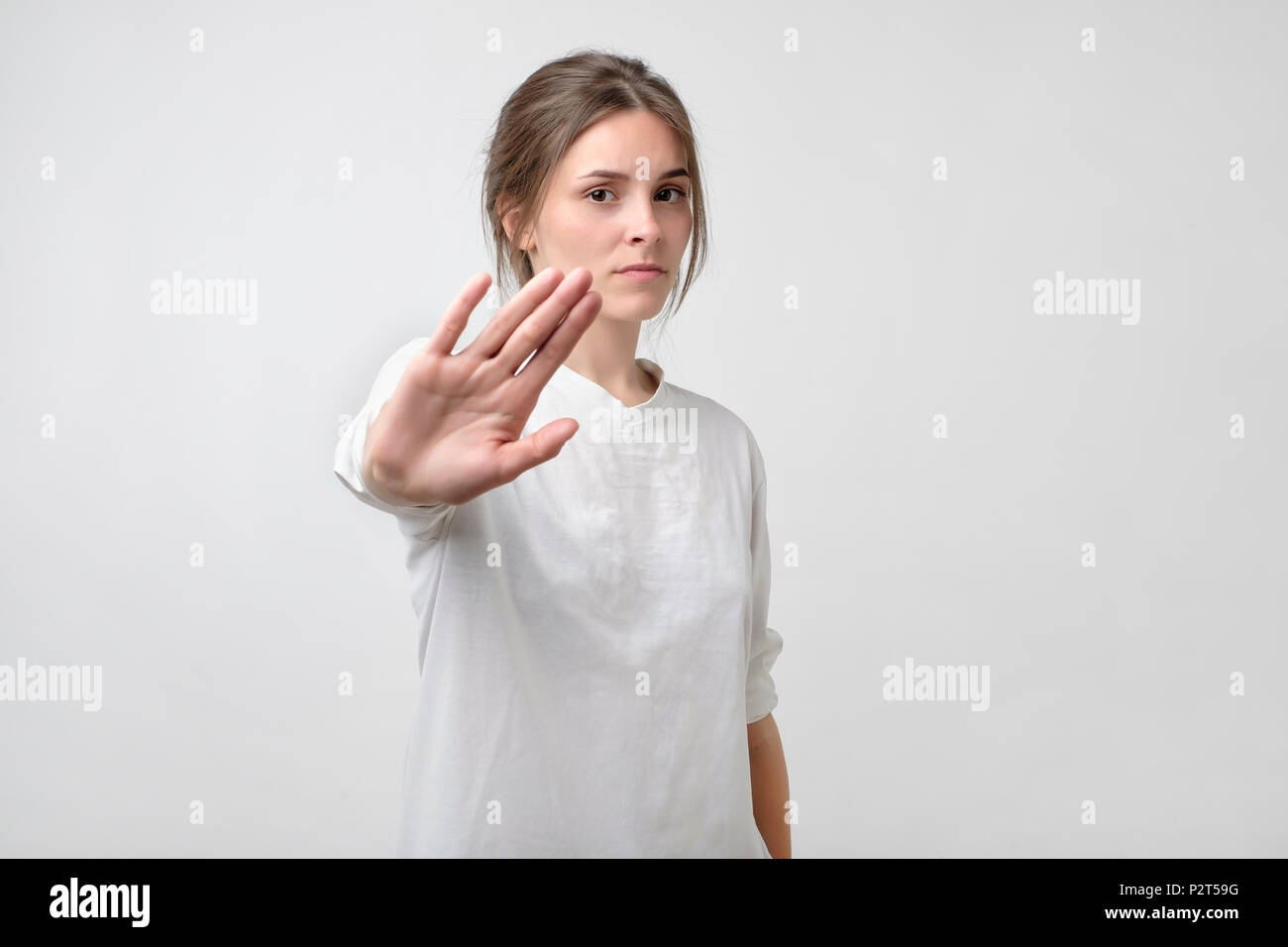 Young woman showing stop sign moving her hand palm to camera. Concept ...