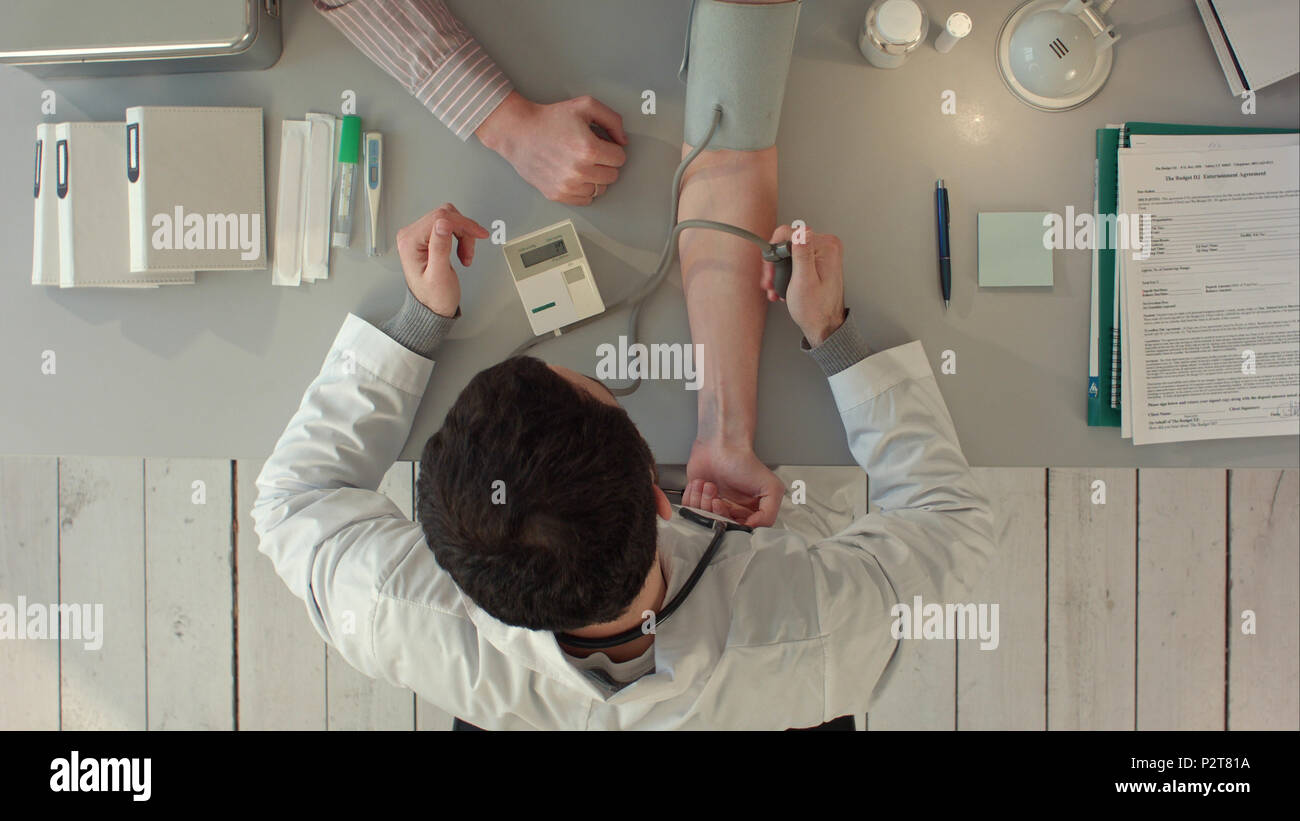 Doctor measuring blood pressure of a patient.. Top view Stock Photo - Alamy
