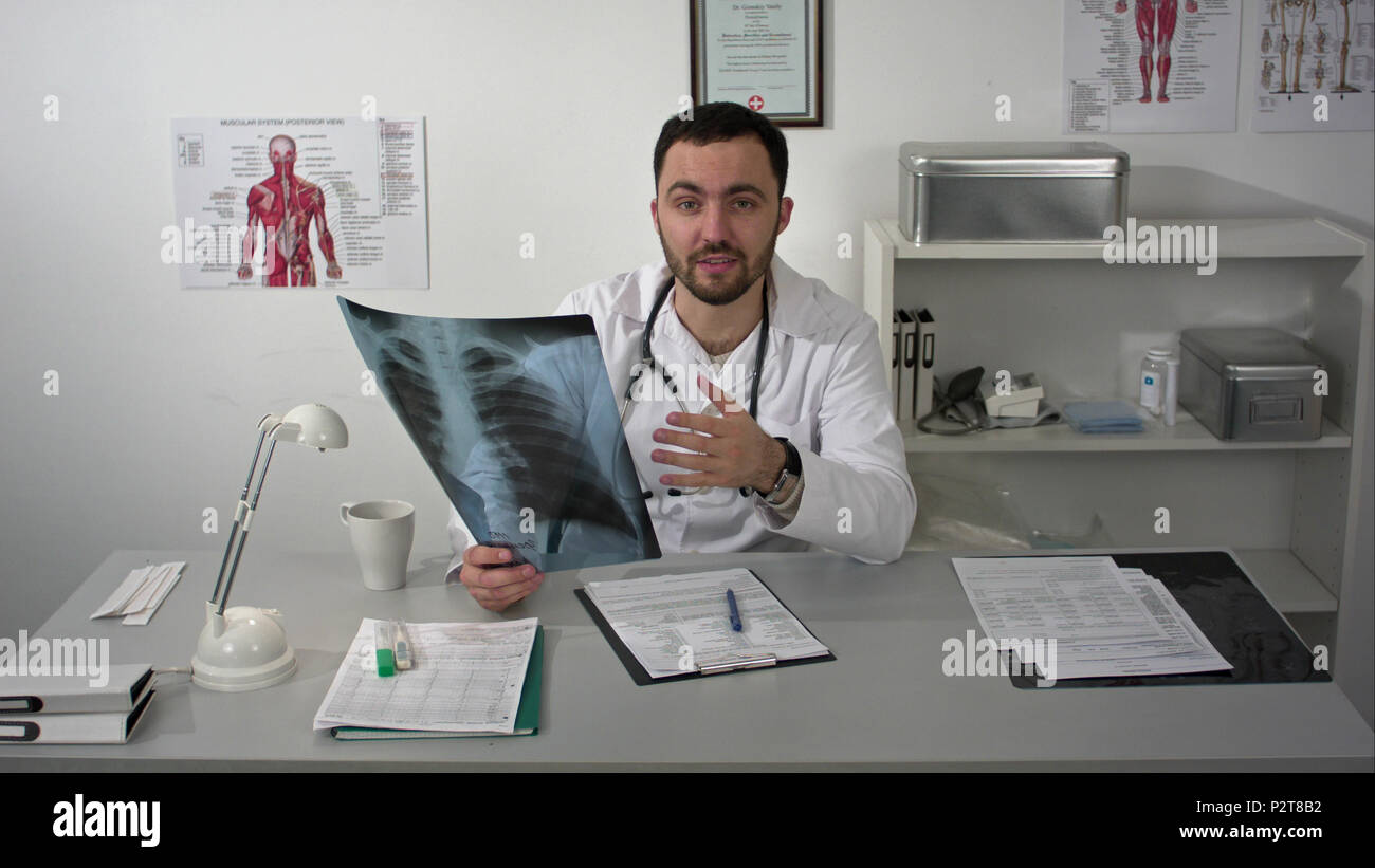 Medical doctor friendly speaking to camera holding x-ray Stock Photo ...