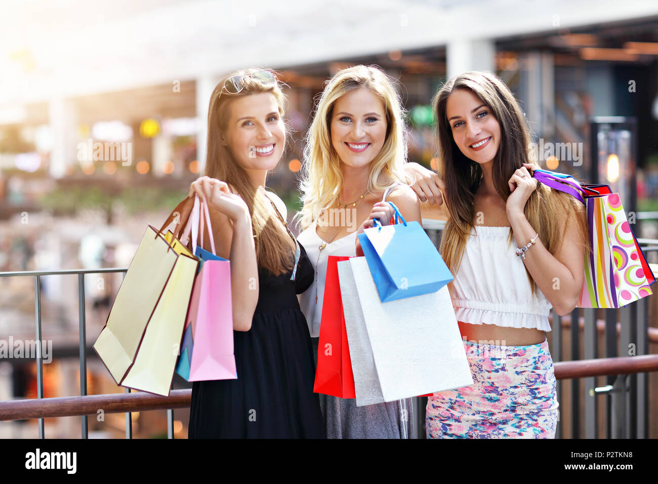 Happy girl friends shopping in mall Stock Photo - Alamy