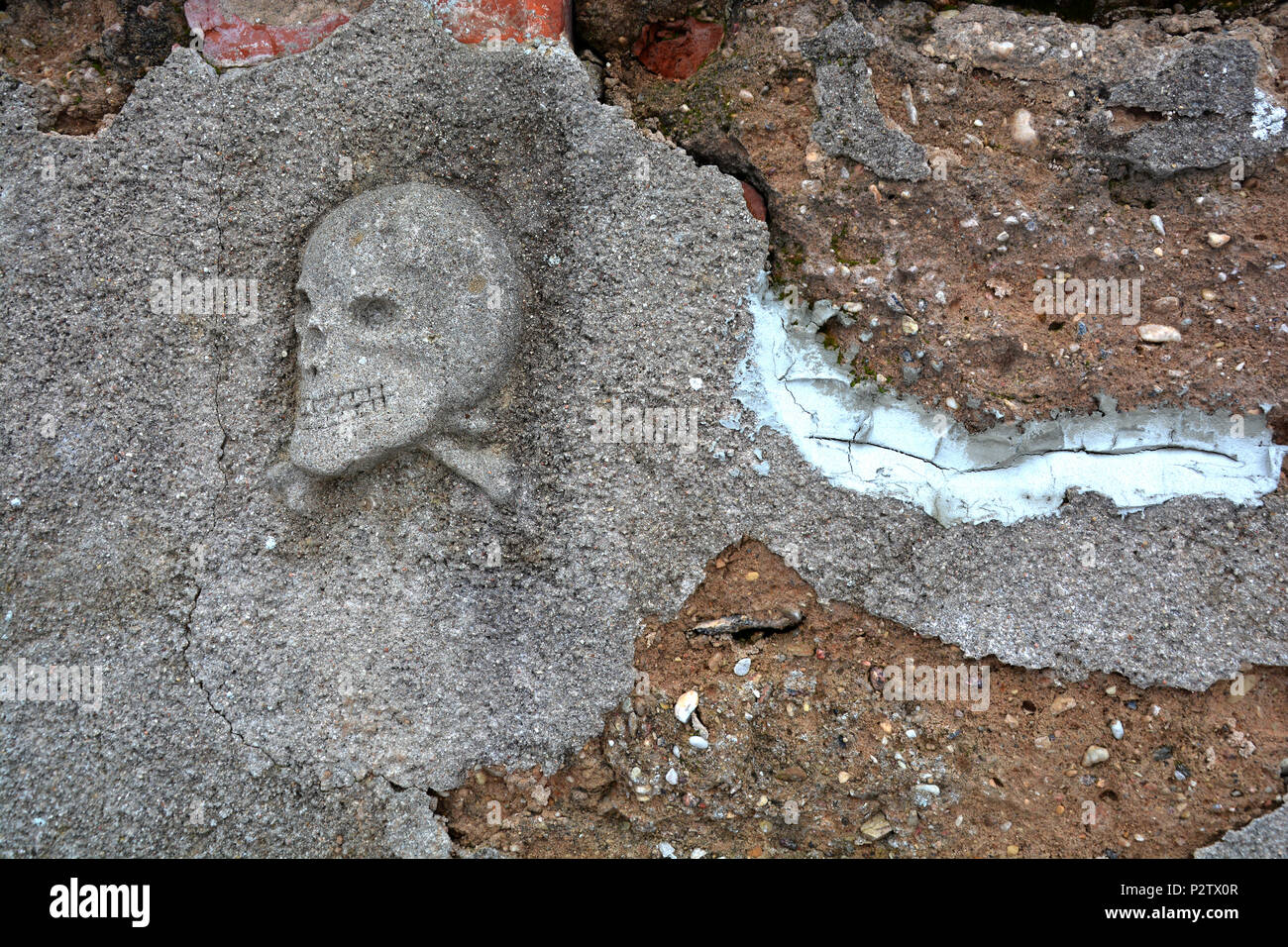 Primitive skull and crossbones relief sculpture on old cemetery fence ...