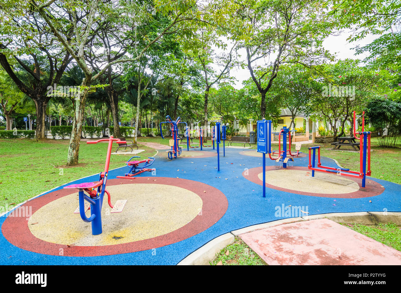 Colorful children playground in public park surrounded by green trees ...