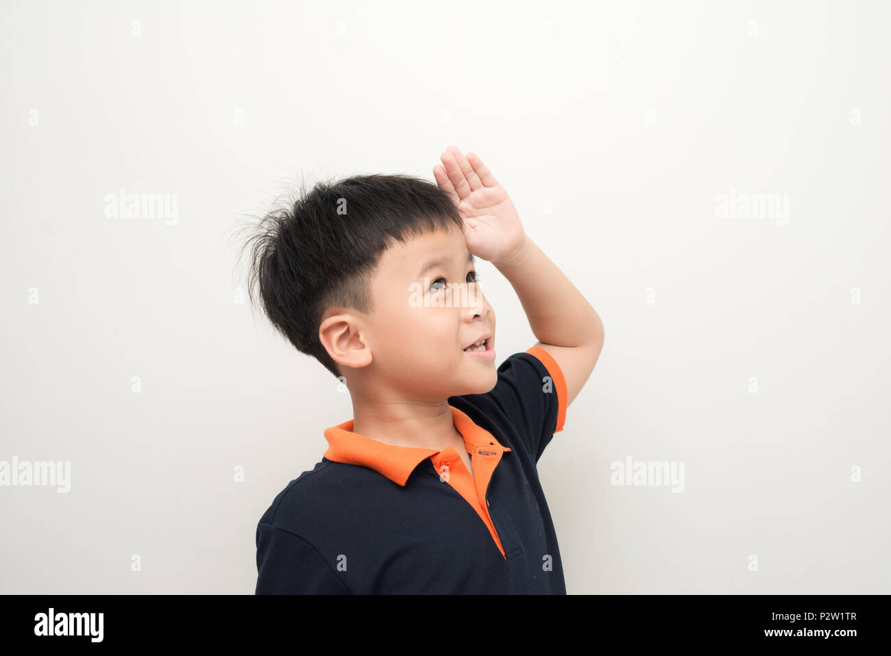 Cute little boy showing a saluting gesture in the studio Stock Photo ...